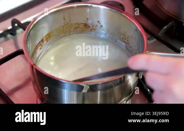 preparing the glaze for Easter from gelatin, whisk, heat hands woman in ...