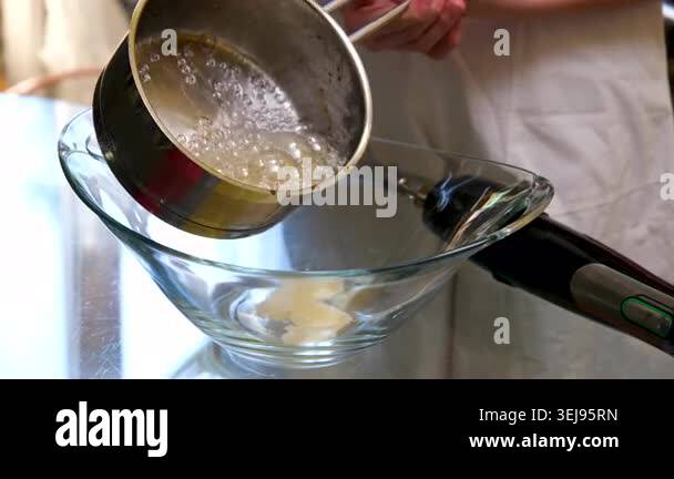 preparing the glaze for Easter from gelatin, whisk, heat hands woman in ...
