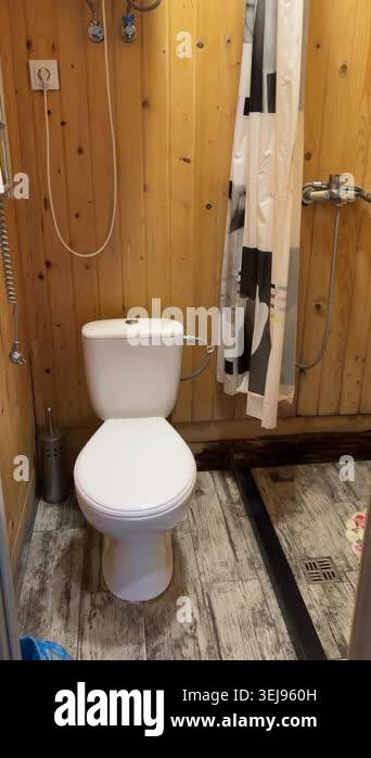 Compact rustic bathroom with toilet and shower curtain inside wooden ...