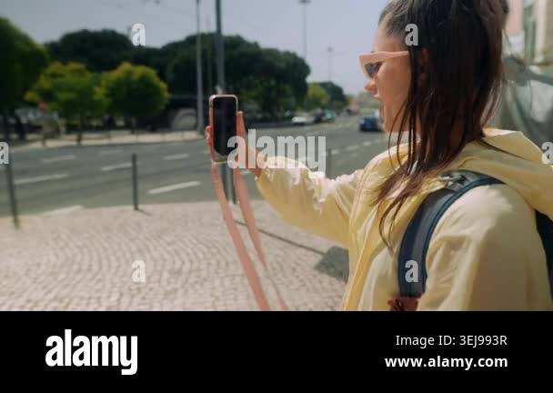Tram stop intersection young woman gestures and holds phone for video ...