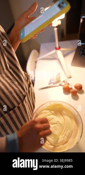 Tabletguided baking mixing batter bowl, hand stirring creamy batter ...
