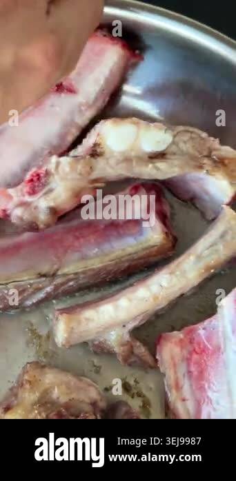 Browning development on pork ribs shown up close, hand rotating pieces ...