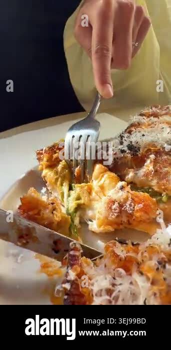 White woman cutting runny yolk toast, fork and knife pulling molten ...