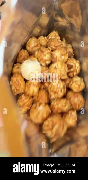 Closeup caramel popcorn inside bag, glossy caramel coating on golden ...