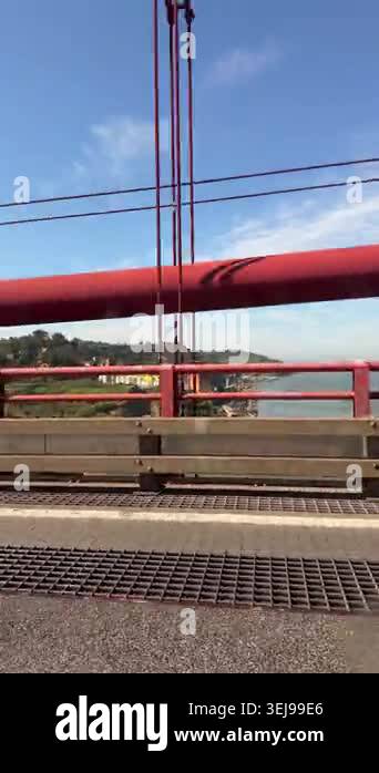 Red bridge railing coastal vista showing bay, cliffs and blue sky with ...