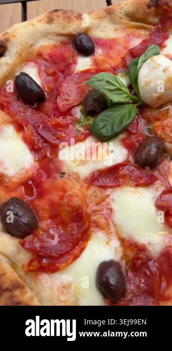 Closeup pepperoni pizza leading into burrata anchovy slice being cut ...