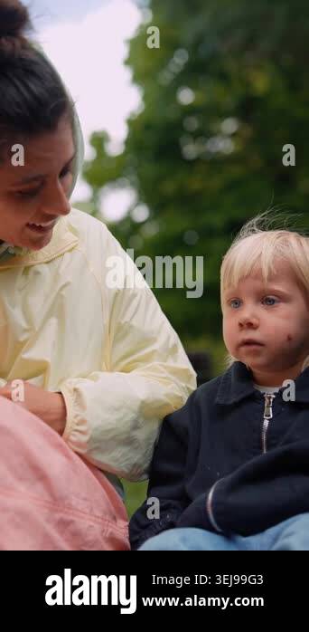 Gentle park chat. Empathetic caregiver speaking gently to child while ...