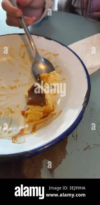 White girl savoring last caramel cake bite, small remainder on enamel ...