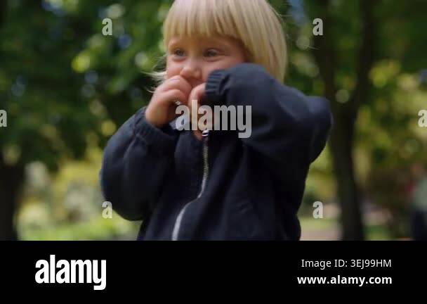 Little blonde girl playing happily outside. Toddler with light hair ...