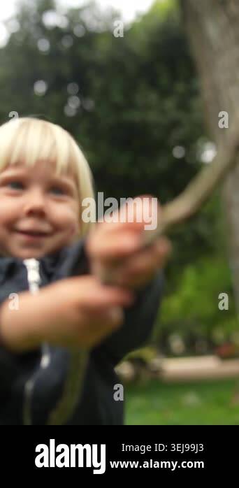 Toddler bending to inspect ground, introspective expression and small ...