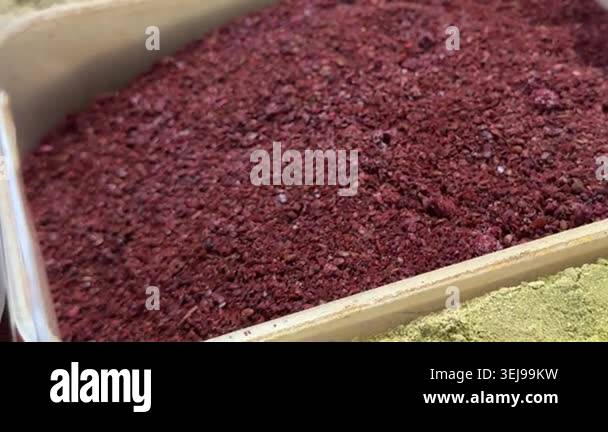 Aromatic sumac seasoning with rich burgundy powder texture stored in ...