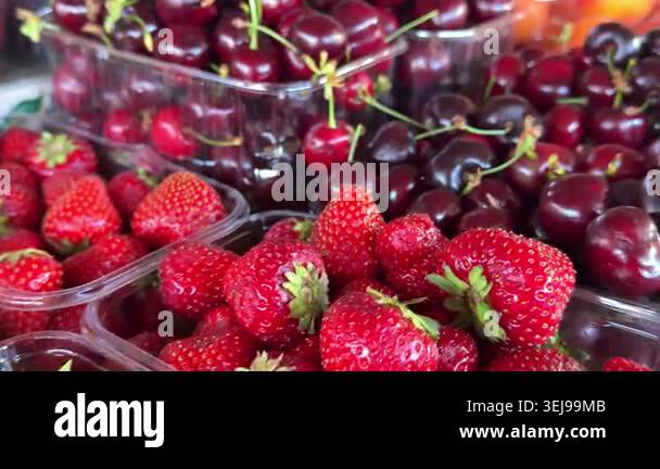 Sweet strawberries dark cherries and ripe apricots displayed in clear ...