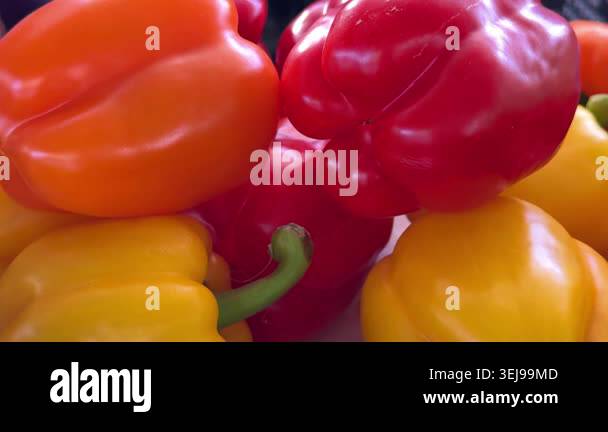 Bright orange yellow and red bell peppers stacked in beautiful colorful ...