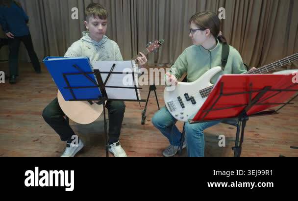 Boy and Girl Practice Playing Music on Stage. Kids Play Guitar and Bass ...