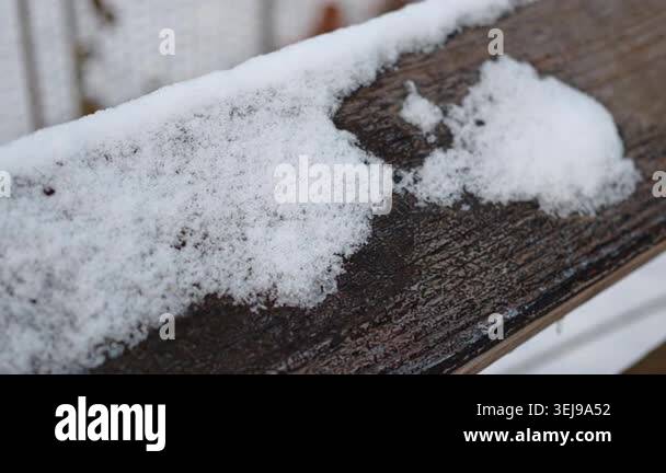 White snow lies on the wooden plunk. Close up. Winter precipitation ...