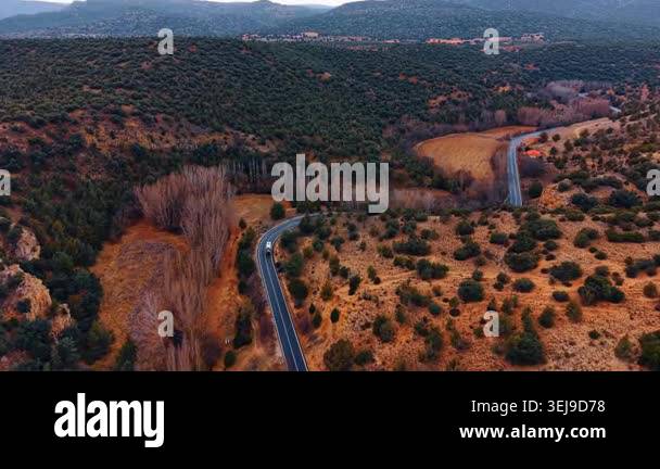 Aerial view of a curved road in a green valley. Winding asphalt highway ...