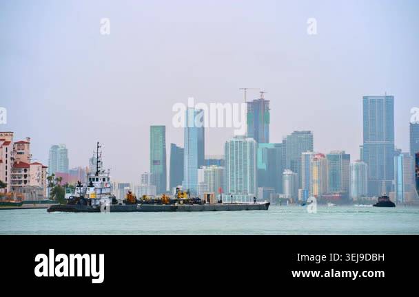 Large unloaded cargo ship sets off the shore. Misty skyline of Miami ...