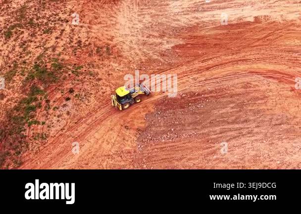 Aerial top down view of yellow excavator on red soil. Construction ...