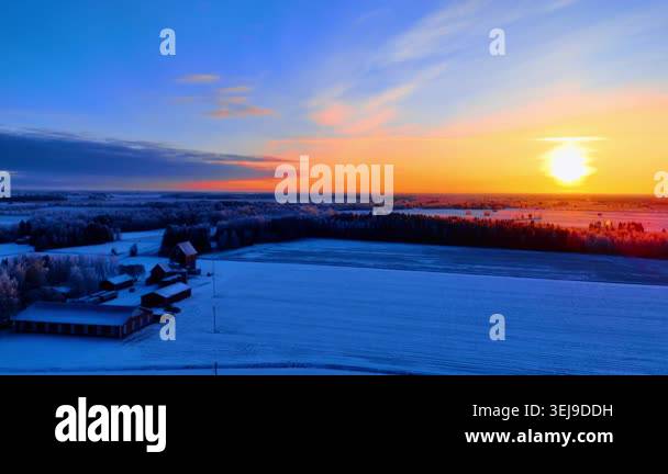 Flight over the snowy field along the secluded houses. Approaching the ...