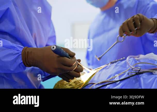 Hands of the unrecognized surgeons in brown latex gloves. Doctors hold ...