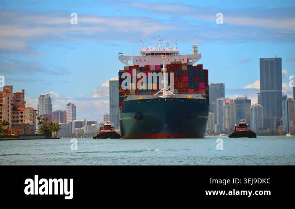 Front view of large container ship with tugboats. Cargo vessel entering ...