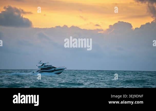 Motor yacht speeding on ocean during golden sunset. Private boat ...
