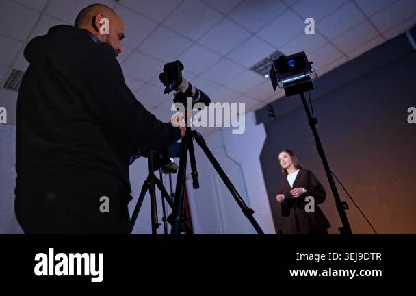 Man wearing black clothes stands near the camera. Low angle view. Woman ...