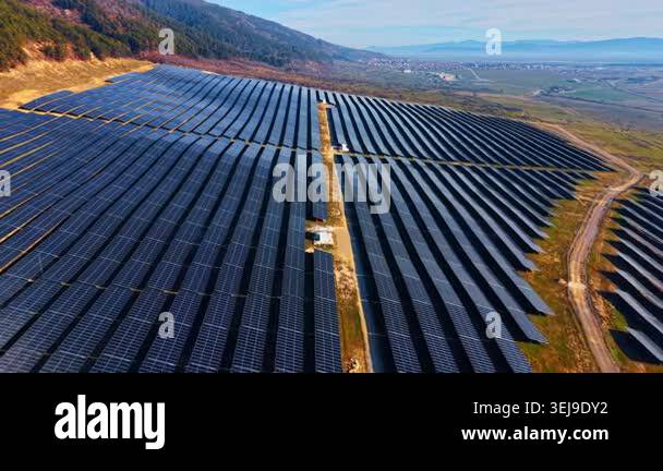 Flight over the long rows of modern photovoltaic cells. Mountain slope ...
