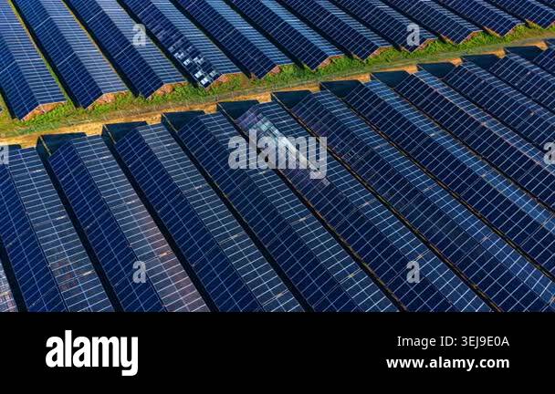 Surfaces of modern solar panels shimmer in the sun. Drone footage over ...