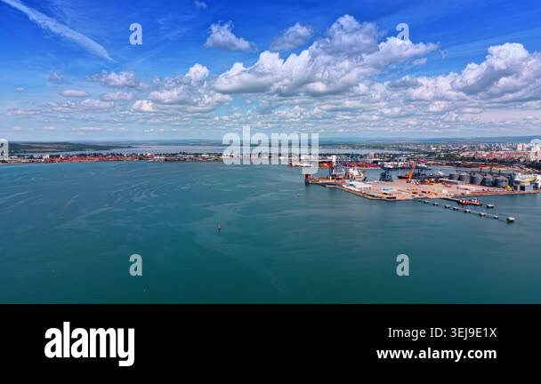 Flying to the port with modern cranes and huge metal tanks. Maritime ...