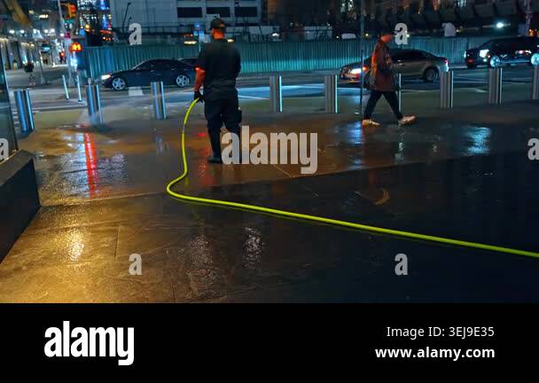 New York, USA, 1 May 2026: Worker Pressure Washing Sidewalk at Night ...