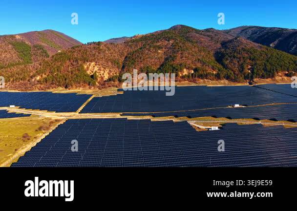 Huge fields of modern solar panels at the mountain foot. Bright sun ...