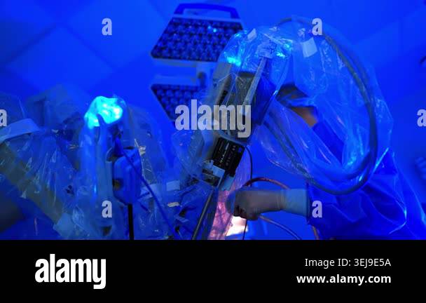 Robotic arms and male doctor's hands move simultaneously at operation ...