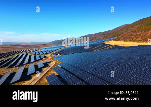 Photovoltaic cell fields at the mountain foot. Bright sun lights the ...