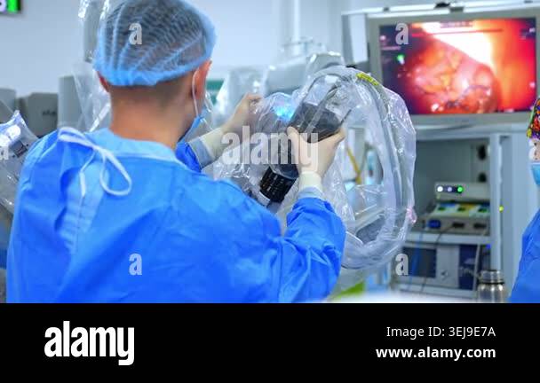 Rear view of a surgeon moving the robotic arm. Operated organ is ...