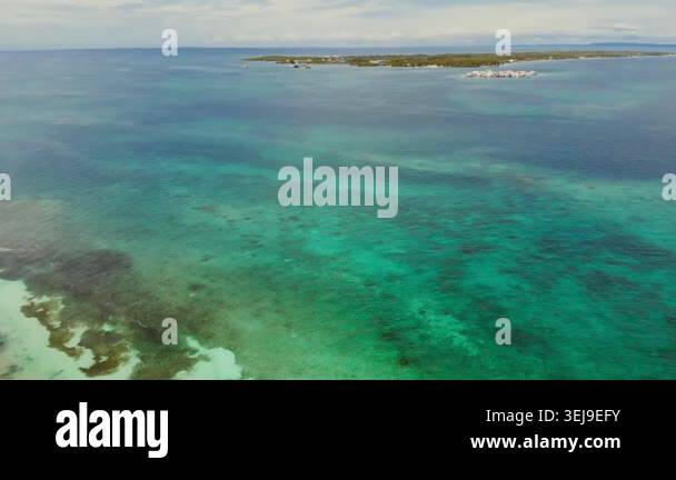 Aerial panning shot of sea color gradients near isla mucura and ...