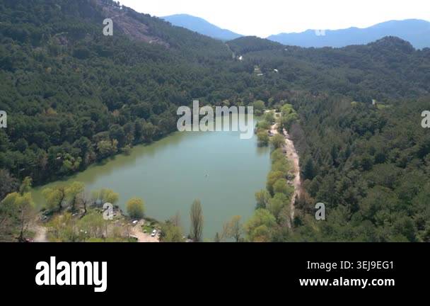 Aerial View of Karagol Lake Surrounded by Dense Green Pine Forest in ...