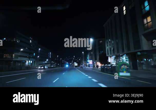 Point of view shot driving a car through the streets of a city at night ...