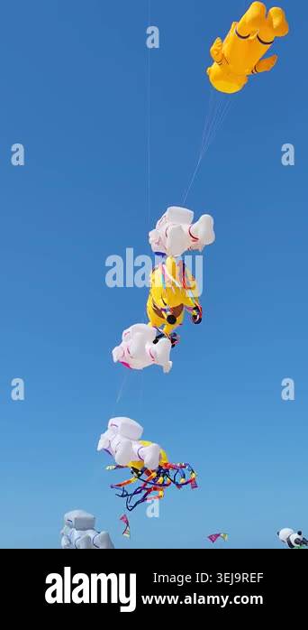 A vertical line of giant, creative inflatable kites shaped like ...