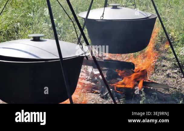 Close-up shot of traditional cast-iron cauldrons (kazan) boiling over a ...