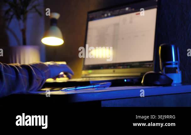 Close up of a man using laptop, signing documents and putting a stamp ...