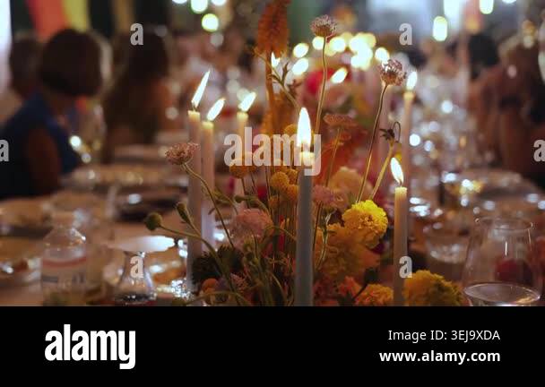 Burning candles in wedding decor with wedding guests at marriage party ...