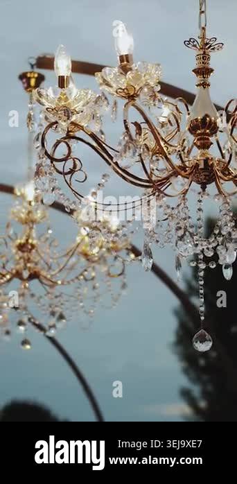 Vertical video. Close-up of elegant crystal chandeliers with glowing ...