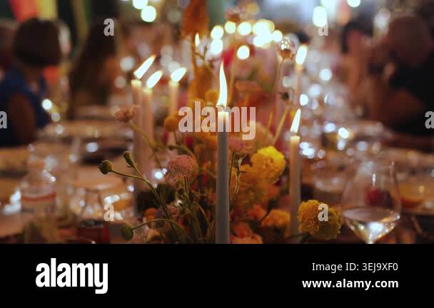 Wedding decor with burning candles and wedding guests at marriage party ...