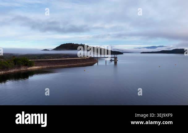 Aerial video showcasing the Glenbawn Dam wall surrounded by a foggy ...