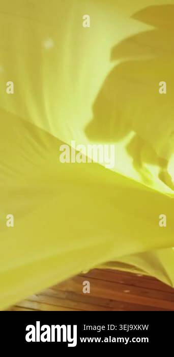 Vertical video. Yellow fabric decoration with light reflections inside ...