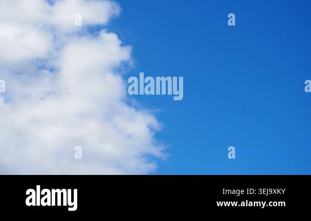Bright clouds move across blue sky on sunny day. Time is during midday ...
