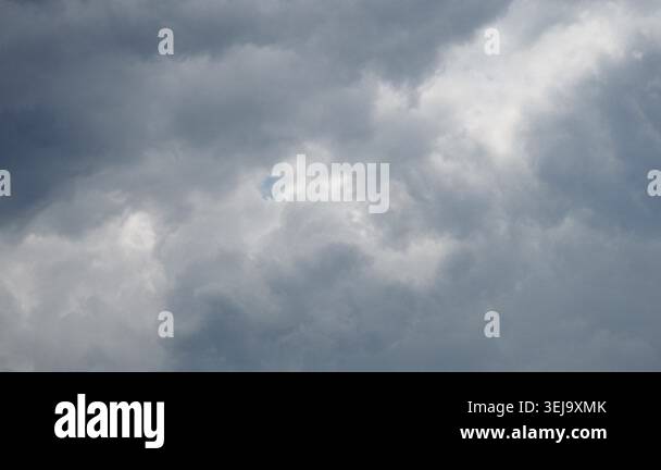 Gray clouds fill the sky and cover the sun. The clouds look thick as ...
