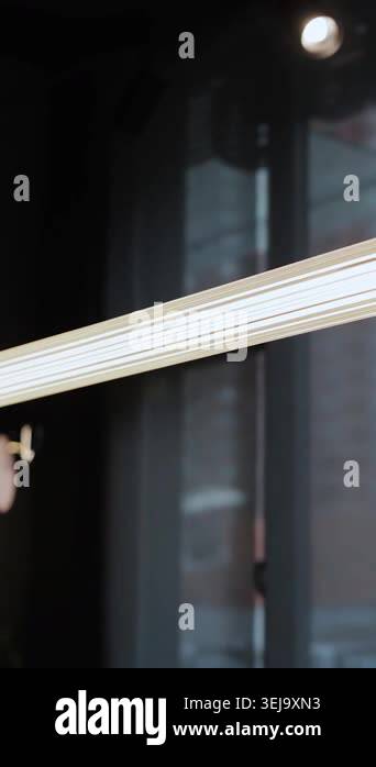 Vertical video. Long modern LED lamp with soft warm lighting in ...
