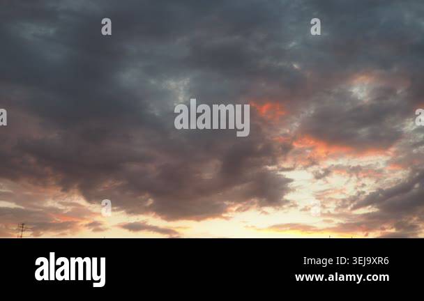 Clouds shift and change above as colors appear during sunset. The sky ...